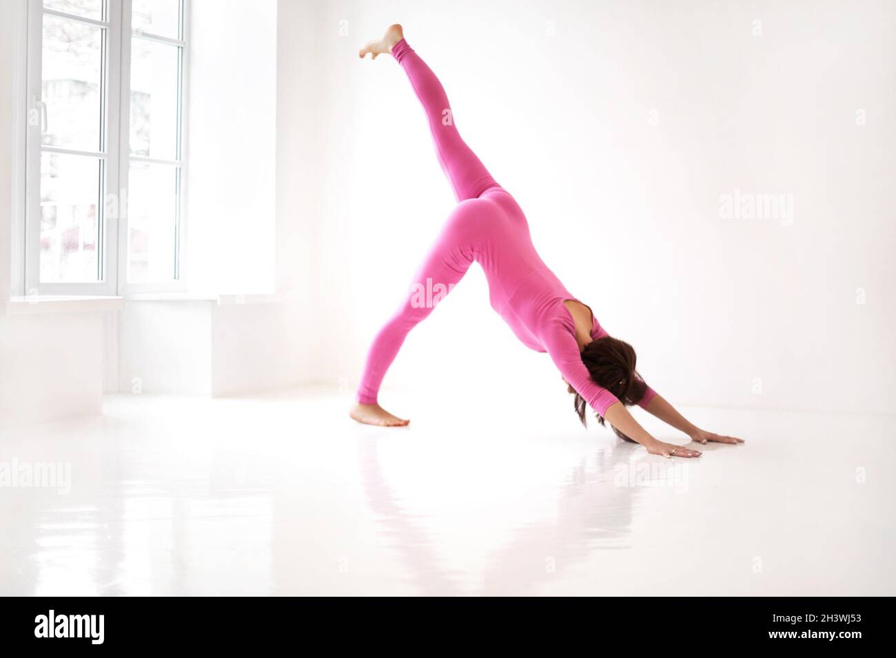 Slim woman doing balancing handstand asana Stock Photo - Alamy