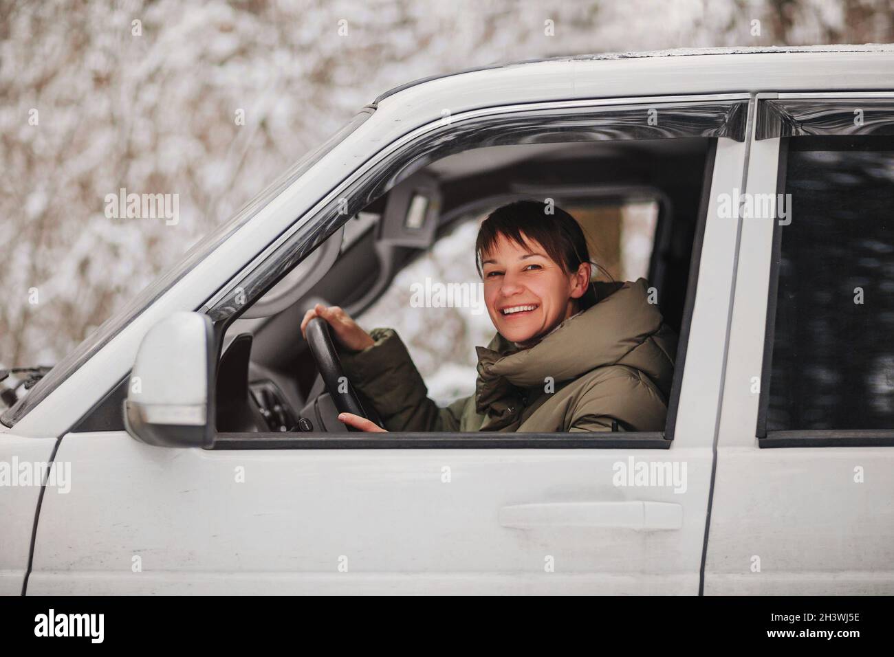 Happy woman driving car in winter Stock Photo - Alamy