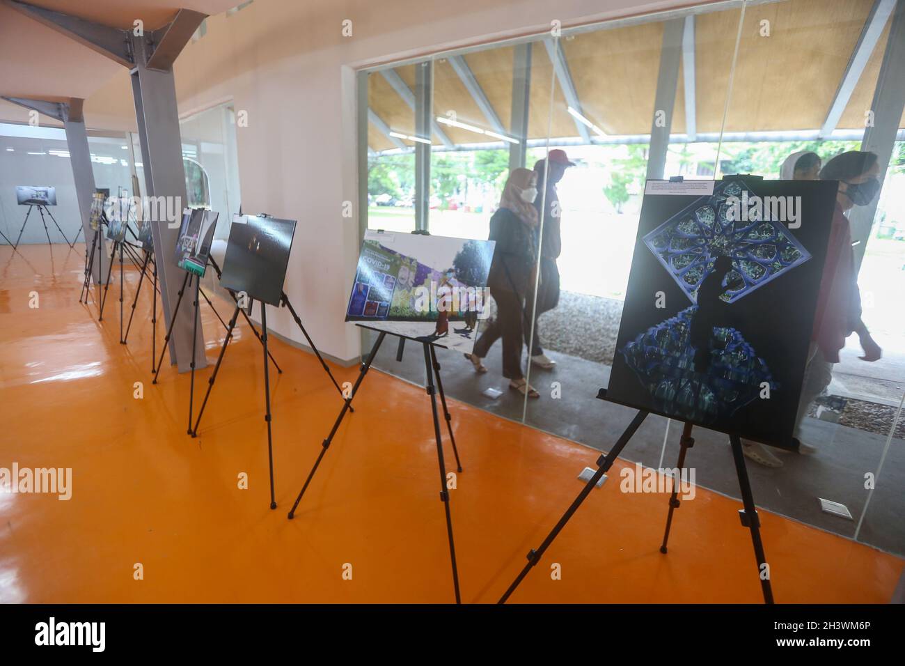 Bogor, Indonesia. 30th Oct, 2021. Visitors observe the photos displayed ...