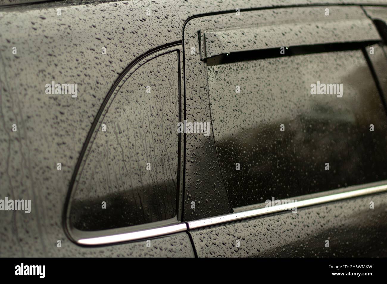 Wet car glass. Drops on transport. Black car in the rain. Machine parts ...