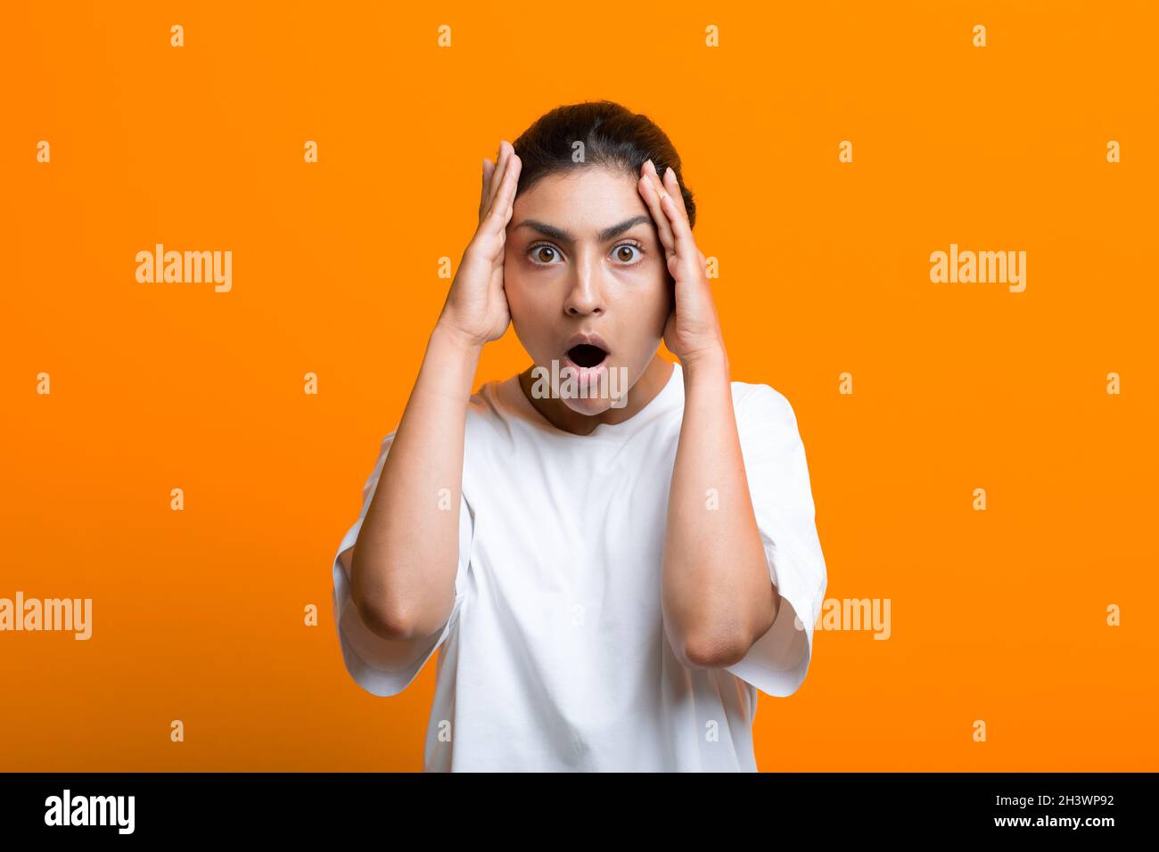 Portrait of young adult scared indian woman in T-shirt Stock Photo - Alamy