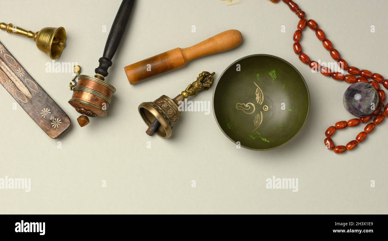 Tibetan singing copper bowl with a wooden clapper on a gray background ...
