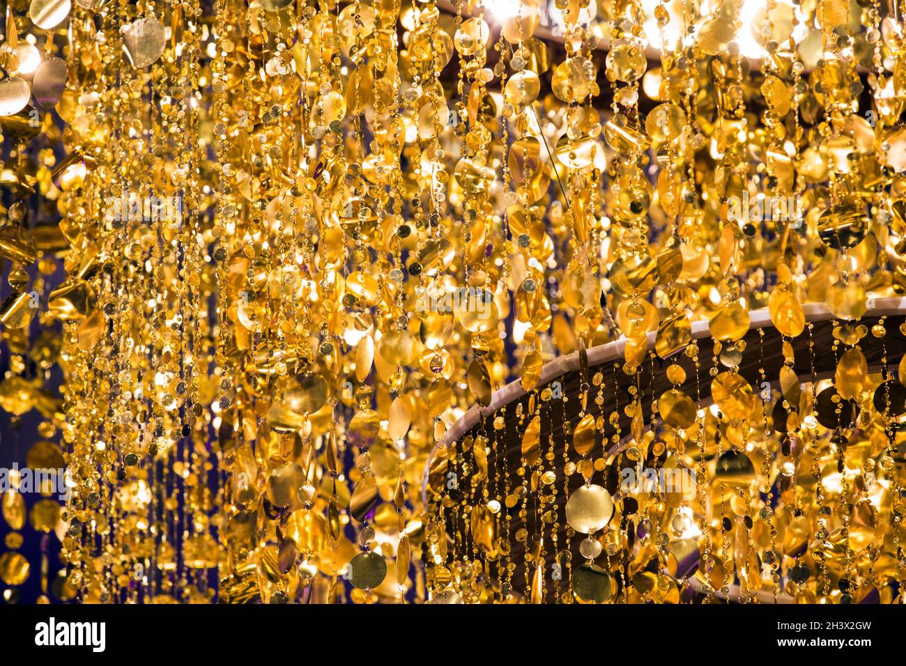 Round, golden, shiny objects hanging down from the ceiling Stock Photo ...