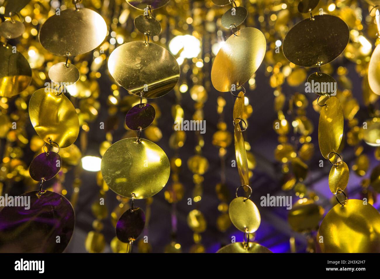 Round, golden, shiny objects hanging down from the ceiling Stock Photo ...