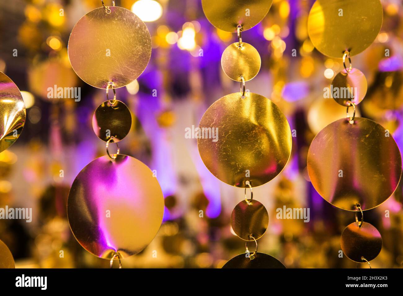 Round, golden, shiny objects hanging down from the ceiling Stock Photo ...