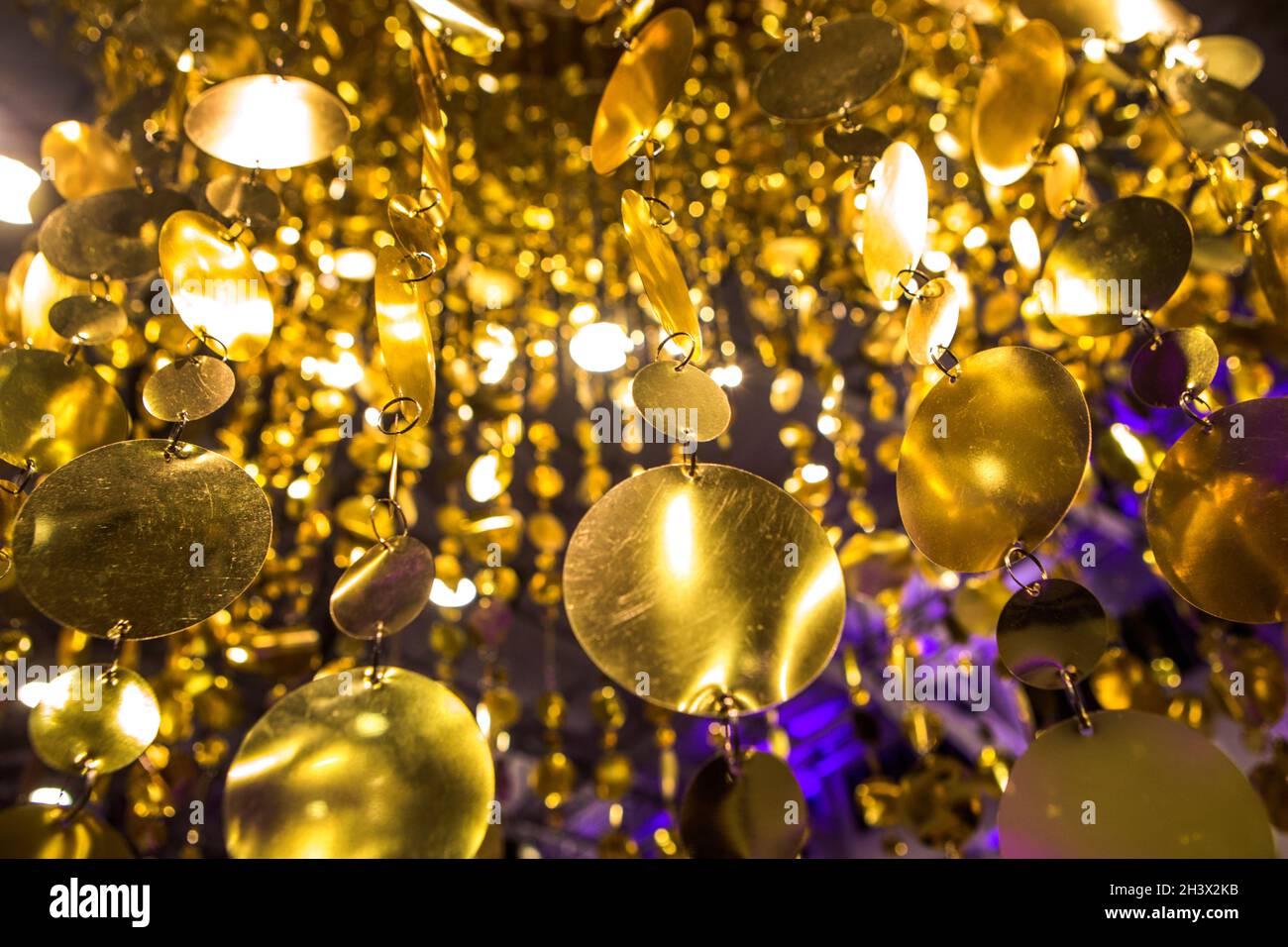 Round, golden, shiny objects hanging down from the ceiling Stock Photo ...