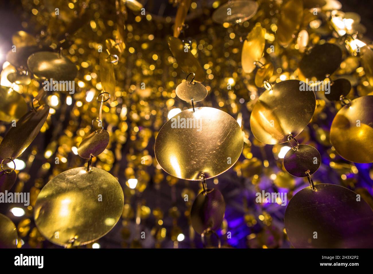 Round, golden, shiny objects hanging down from the ceiling Stock Photo ...