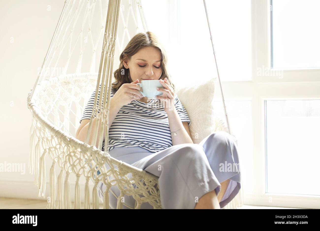 Beautiful young brunette woman drinking coffee while relaxing in ...