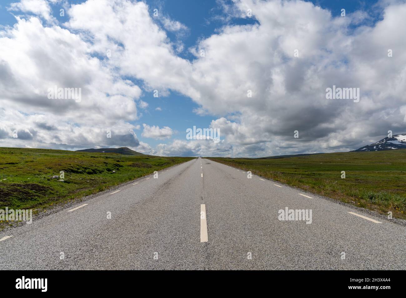 A low angle view of a paved highway leading straight to the horizon in ...