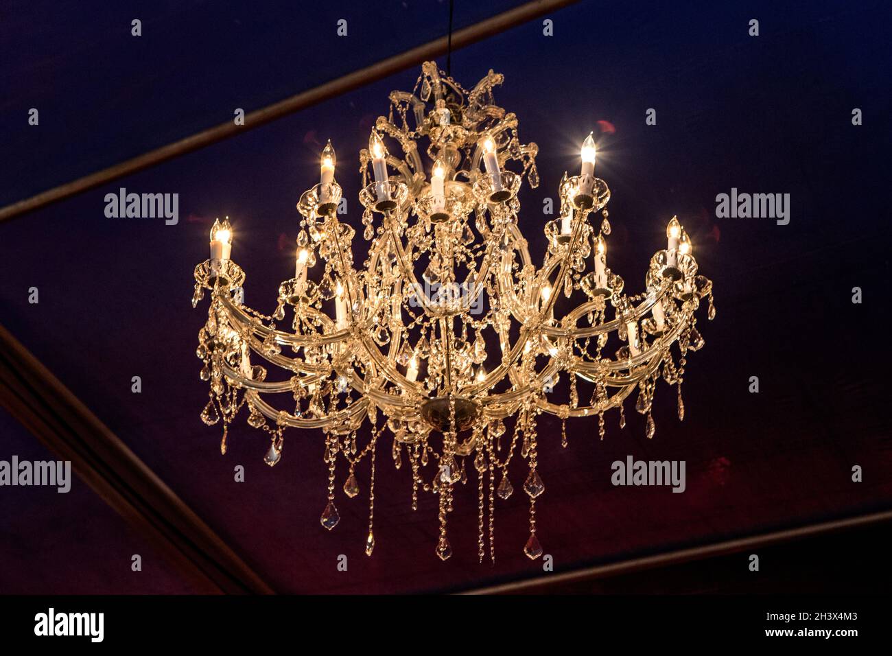 A chandelier hangs down from a ceiling at an event Stock Photo - Alamy