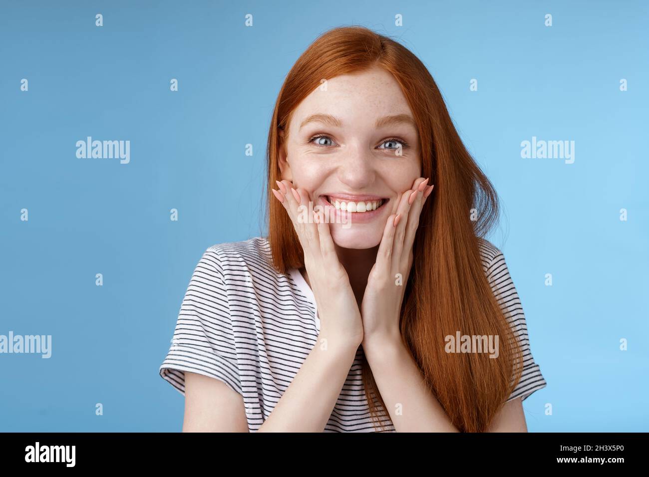 Excited happy cheerful redhead ginger girl smiling joyfully touch ...