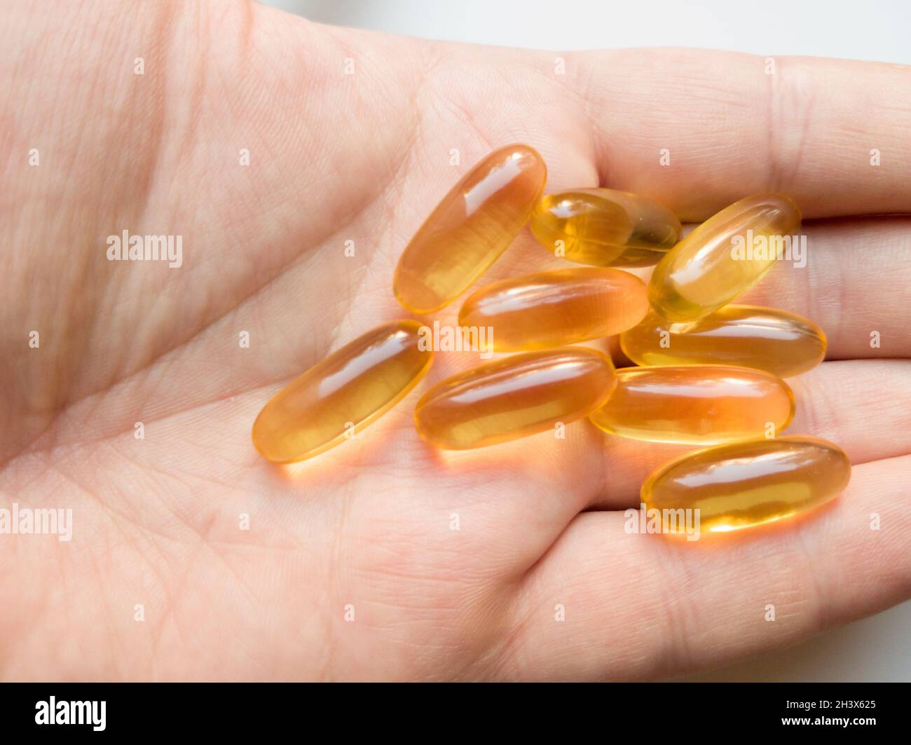 Male hand hold cod liver oil omega-3 gel capsules close-up. Hand ...