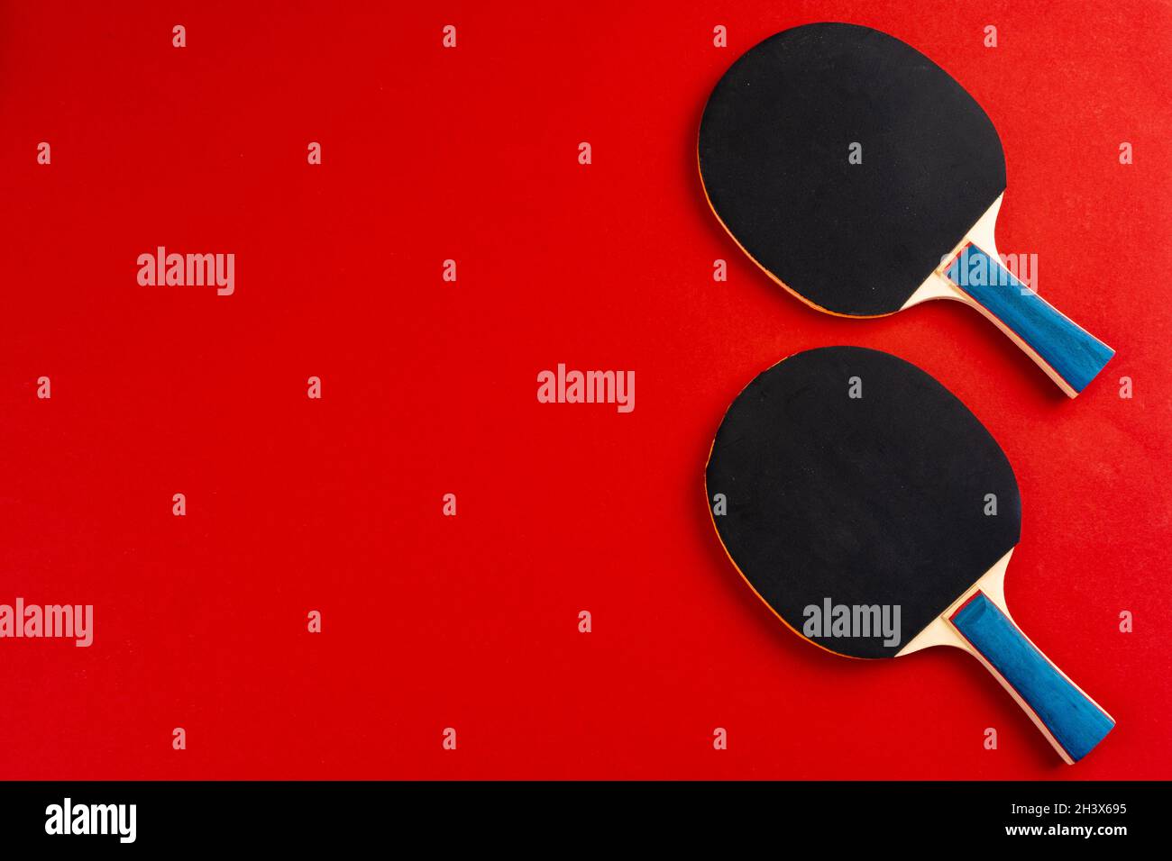 Black ping pong rackets on red background Stock Photo - Alamy