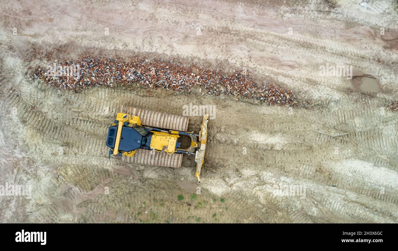 Excavator or bulldozer at work on industrial construction site. Aerial ...