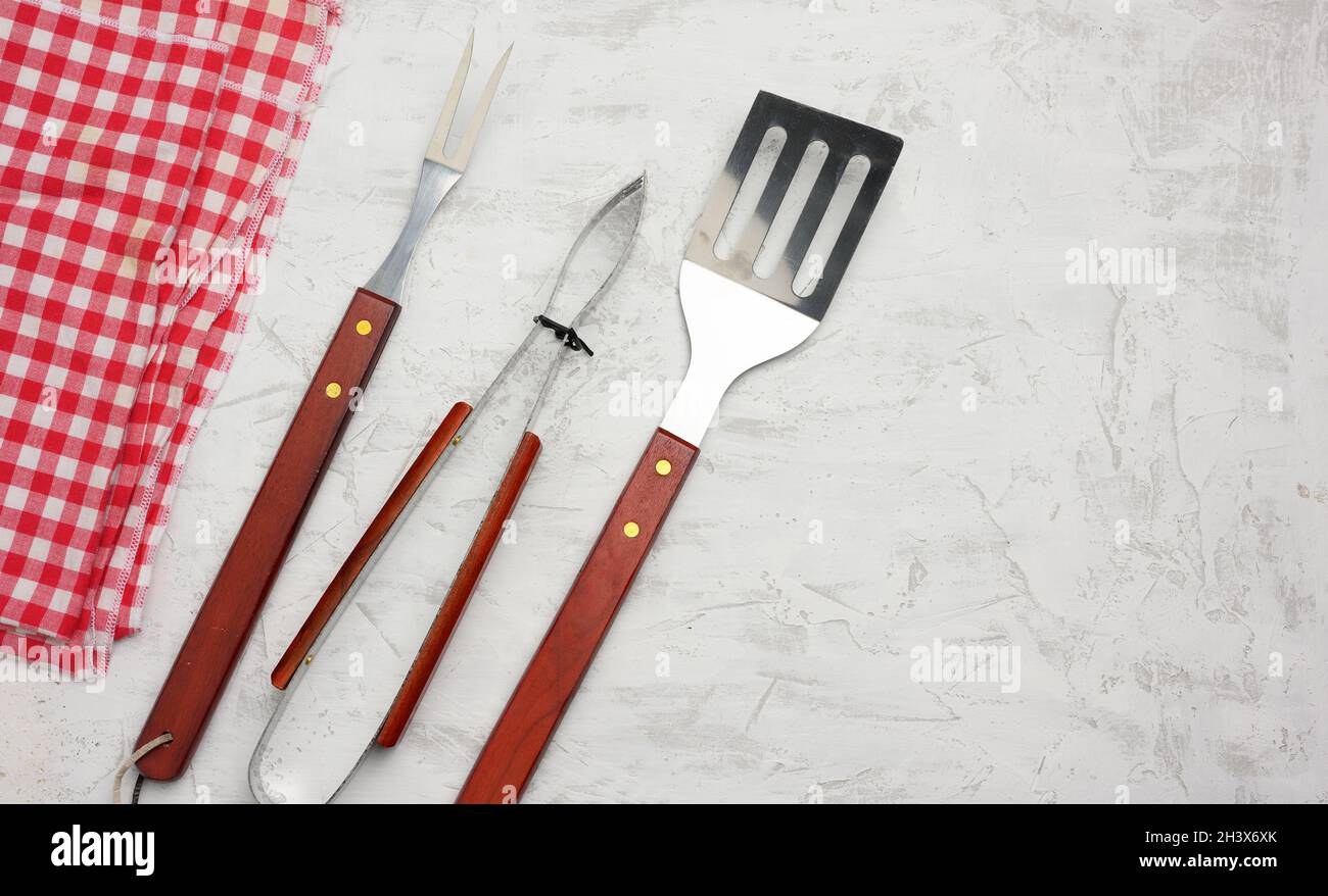 Metal kitchen items with wooden handles for barbecue on white ...