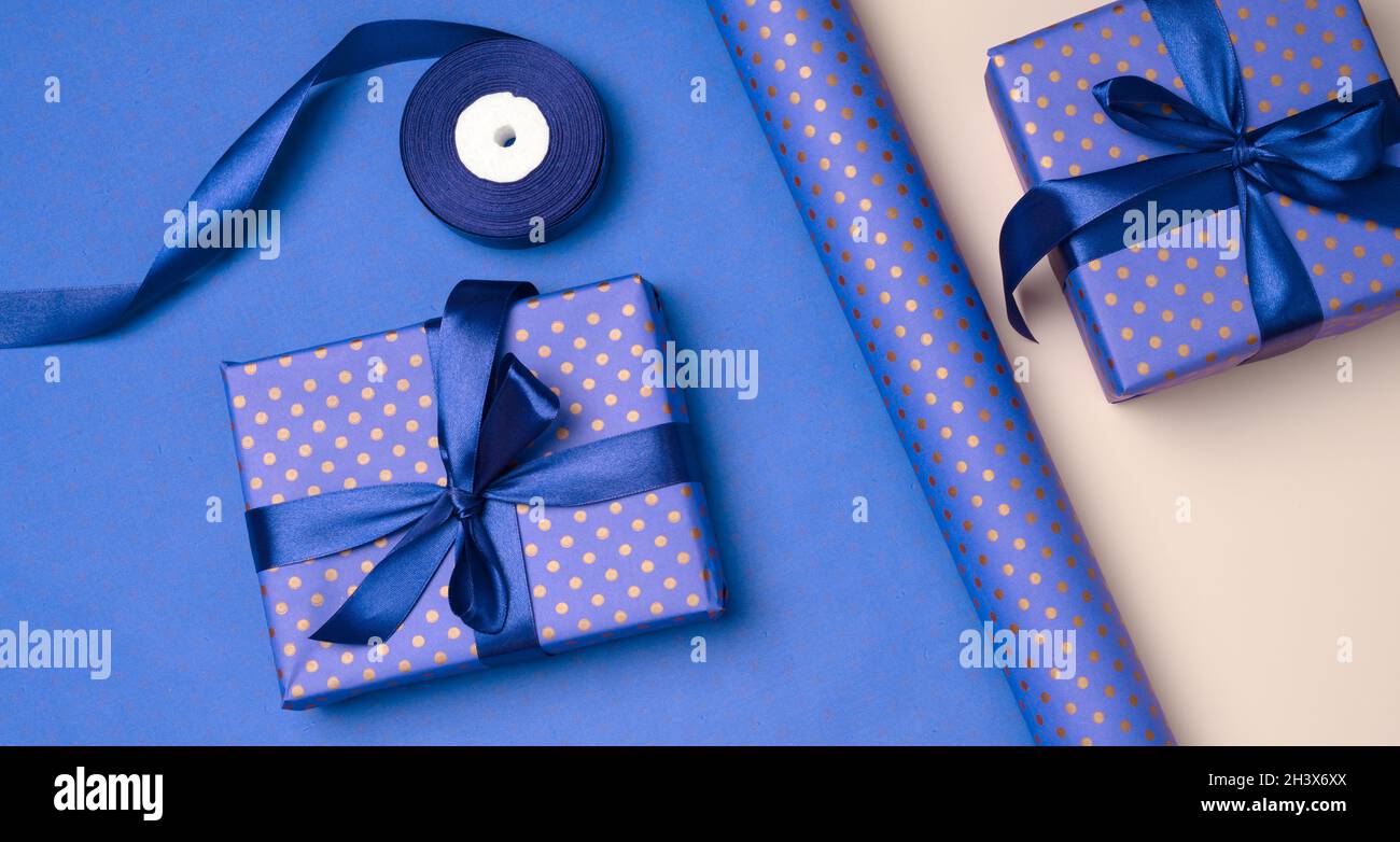 Blue gift box wrapped in silk ribbon on a bluee background Stock Photo ...