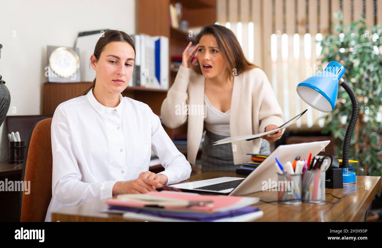 Unhappy woman chief screaming to young female manager Stock Photo - Alamy