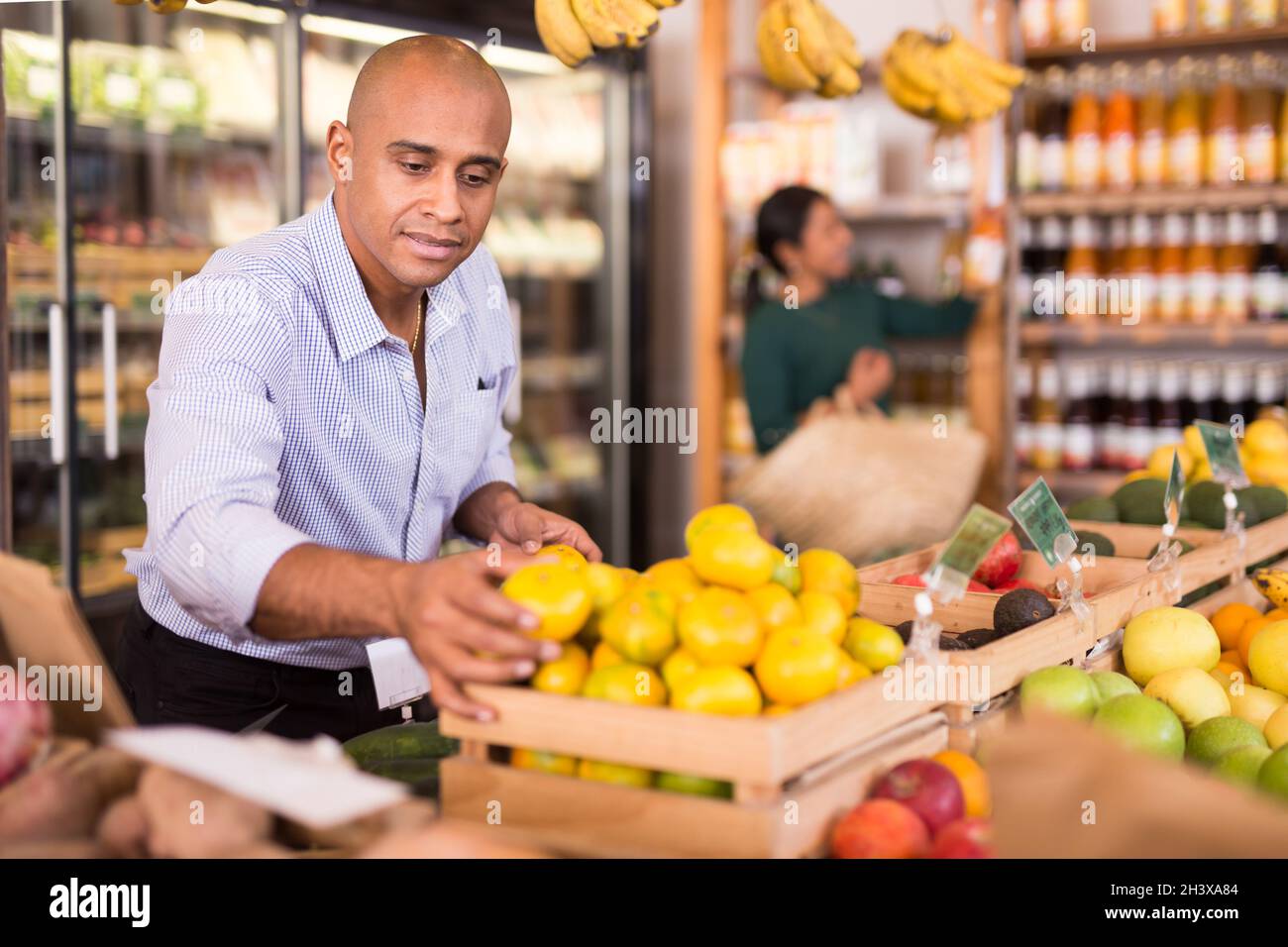 Male consumer choosing tangerines in supermarket Stock Photo - Alamy