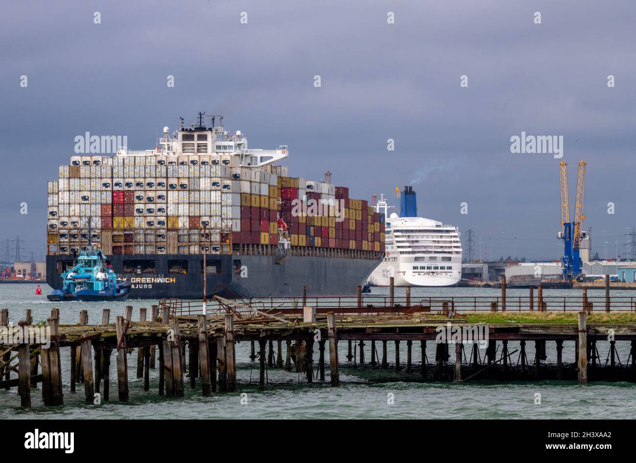 large container ship in the port of southampton docks with a tug on the ...