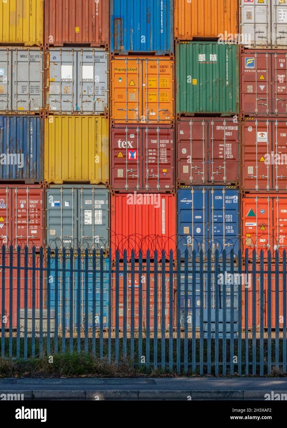 stack of colourful shipping containers in a compound awaiting dispatch ...
