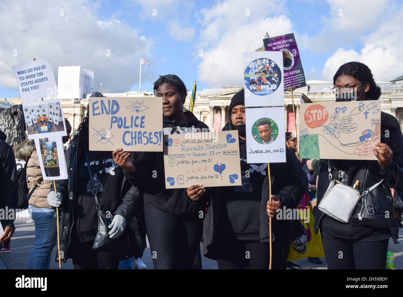 Protesters hold placards demanding an end to police violence, during ...