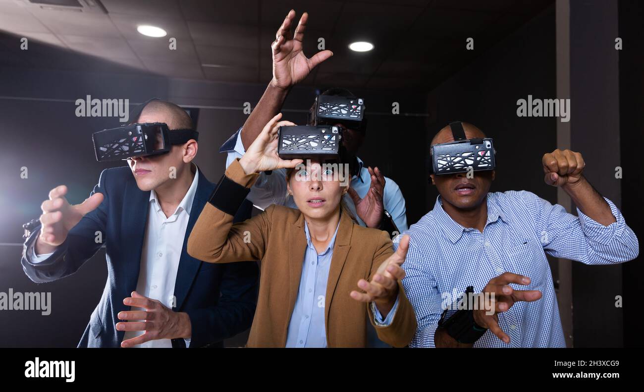 Group of friends are wearing virtual reality goggles in quest room ...