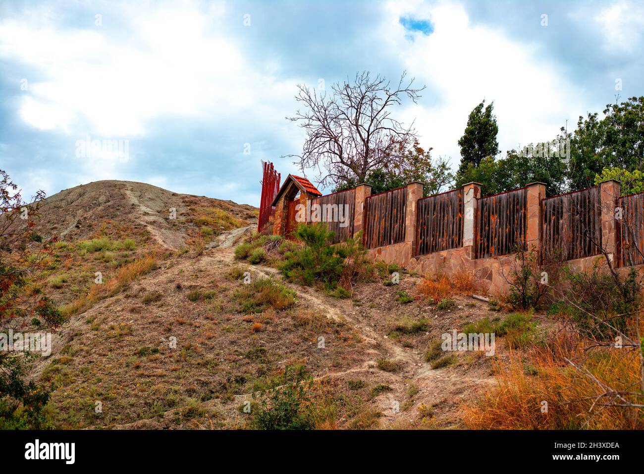 A fence with an entrance rises high in the mountains. Beautiful ...