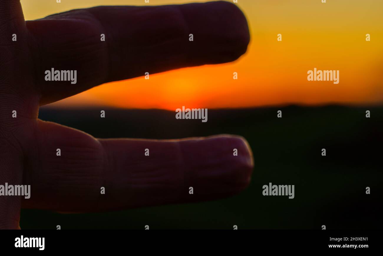 fingers silhouette the last of the golden sunset, minimal cloud on the ...