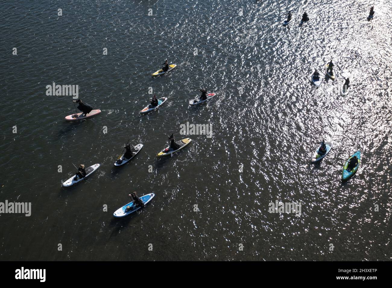 People take part in the Fourth Annual Stand Up Paddleboard Witch Paddle ...