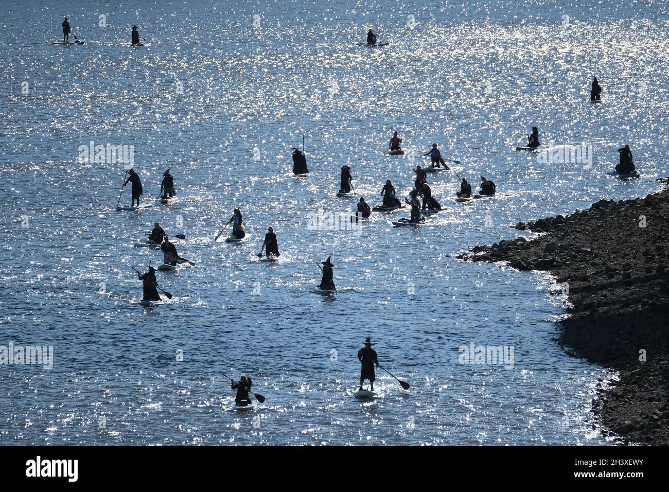 People take part in the Fourth Annual Stand Up Paddleboard Witch Paddle ...