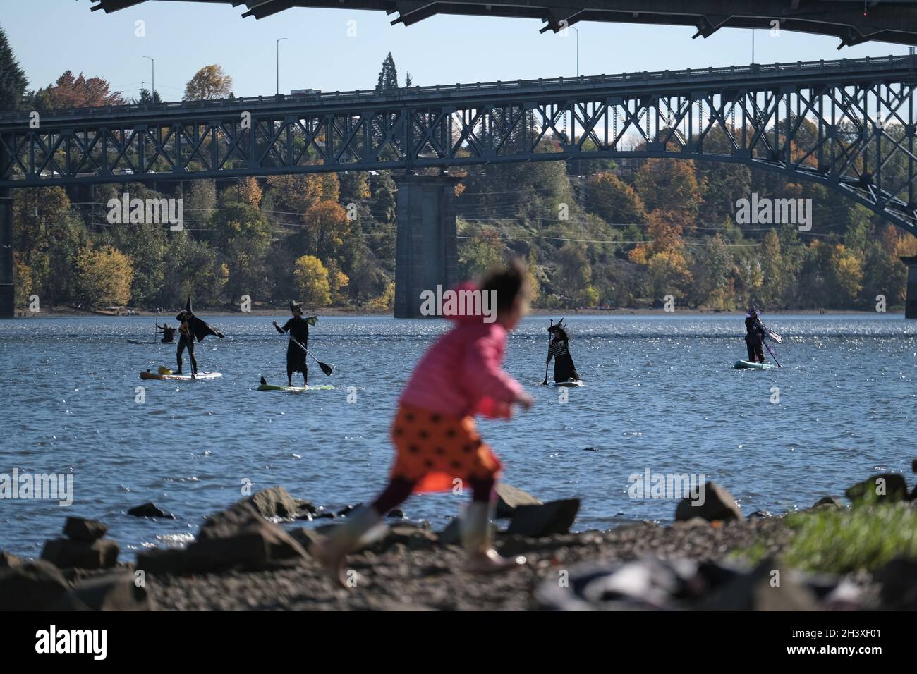 A kid watches from the shore as people take part in the Fourth Annual ...