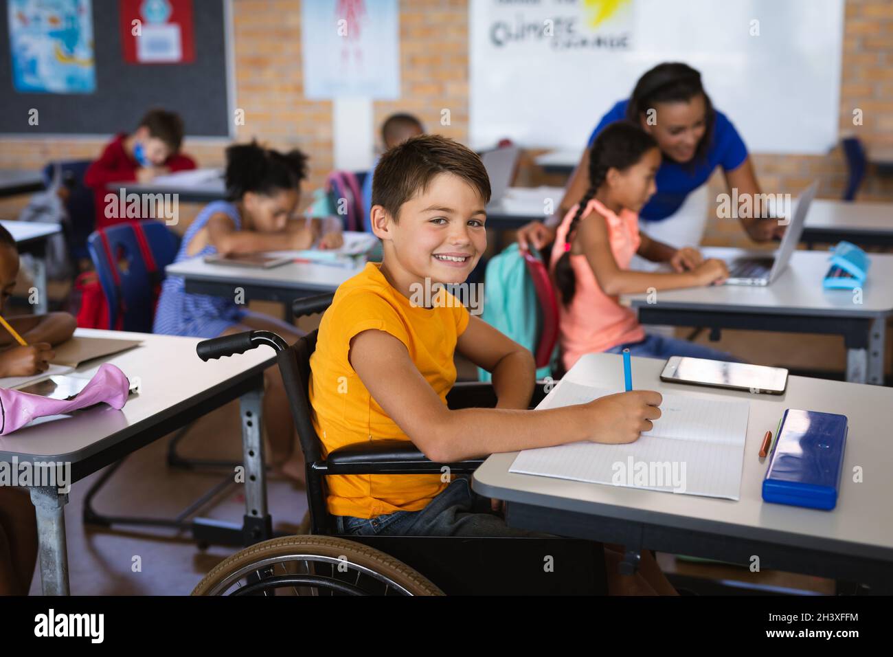 Portrait of disabled caucasian boy smiling while sitting on wheelchair ...