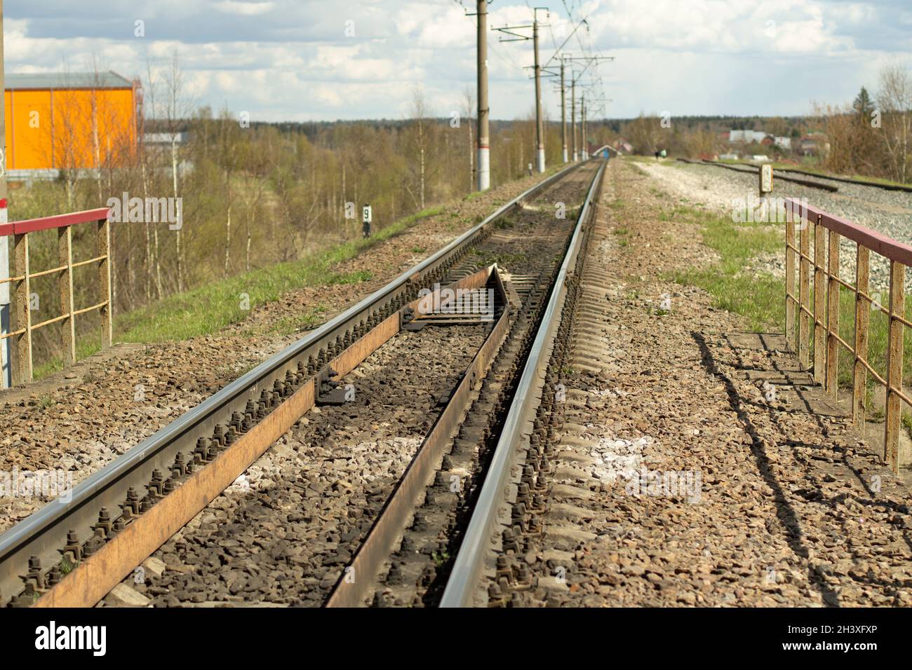 The railway is one lane. The line converges in the distance. The road ...