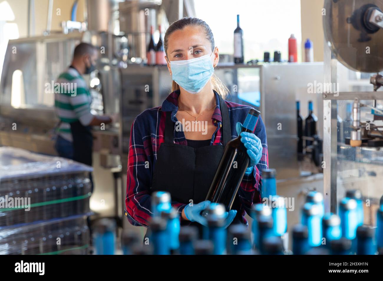 Worker of winery posing with bottled wine Stock Photo - Alamy