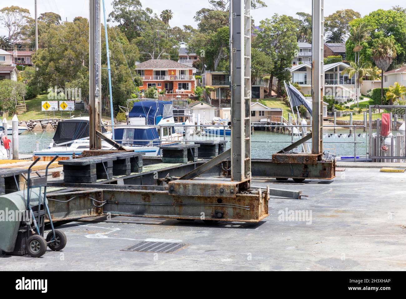 Working boat marina on Pittwater in Sydney with crane hoist and other ...