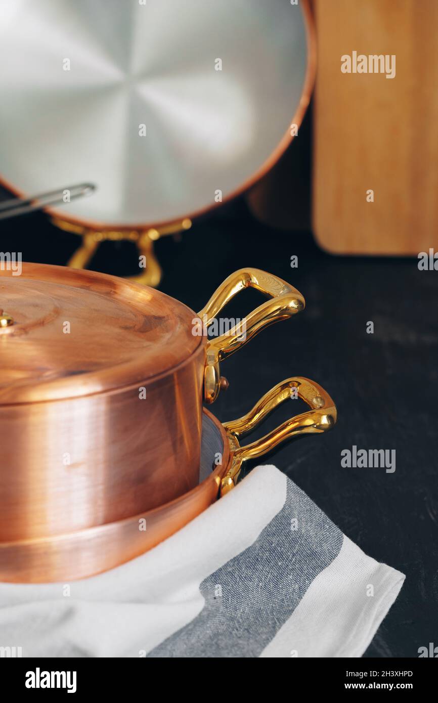 Copper cookware with wooden kitchen utensils close up Stock Photo - Alamy
