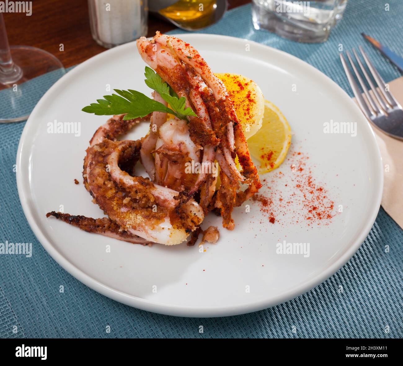 Roasted squid legs with lemon Stock Photo - Alamy