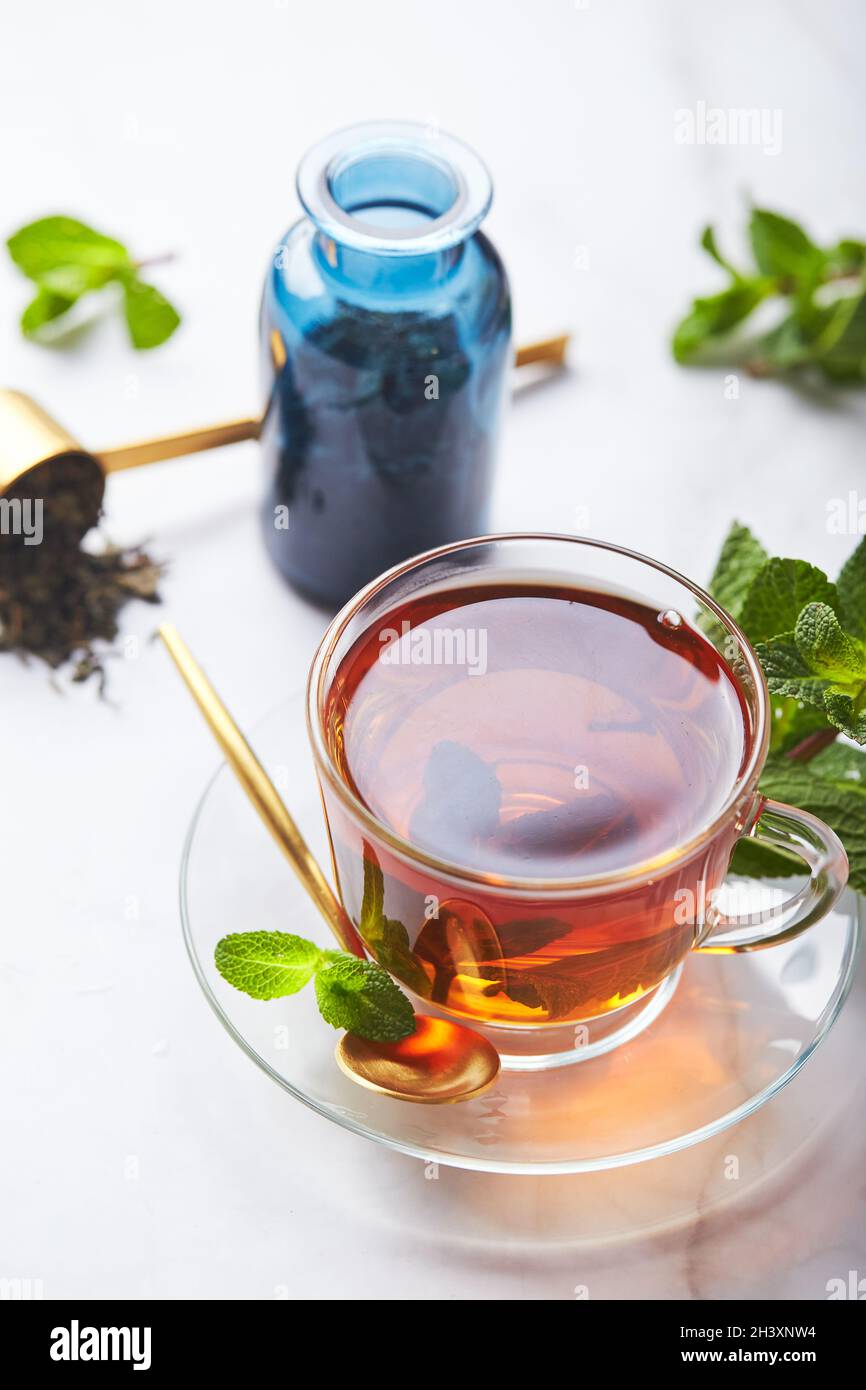 Black tea in glass transparent mug with mint leaves. Soothing tea, anti ...