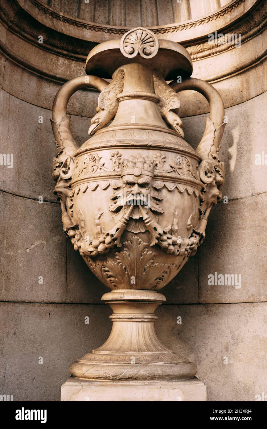 Antique flowerpot in an old hall with patterns and a bas-relief image ...