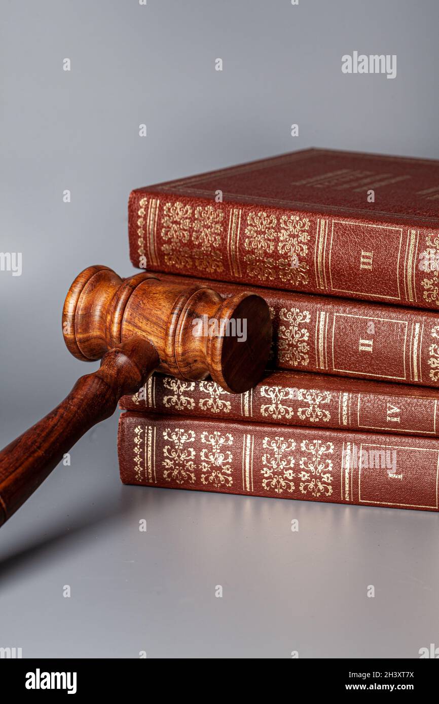 Brown wooden gavel with stack of books on gray table Stock Photo - Alamy