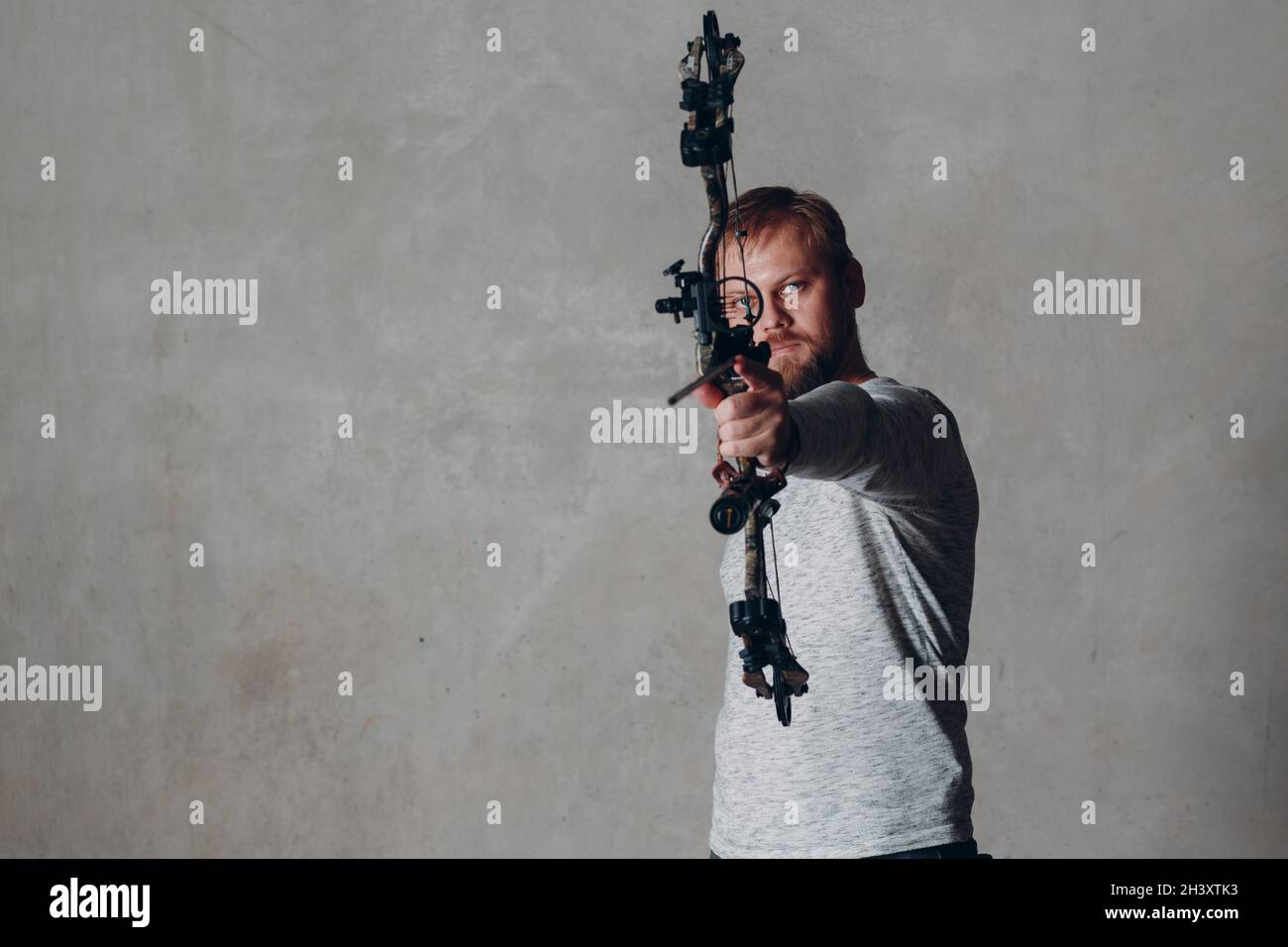 Archer man with modern block sport bow and arrow Stock Photo - Alamy