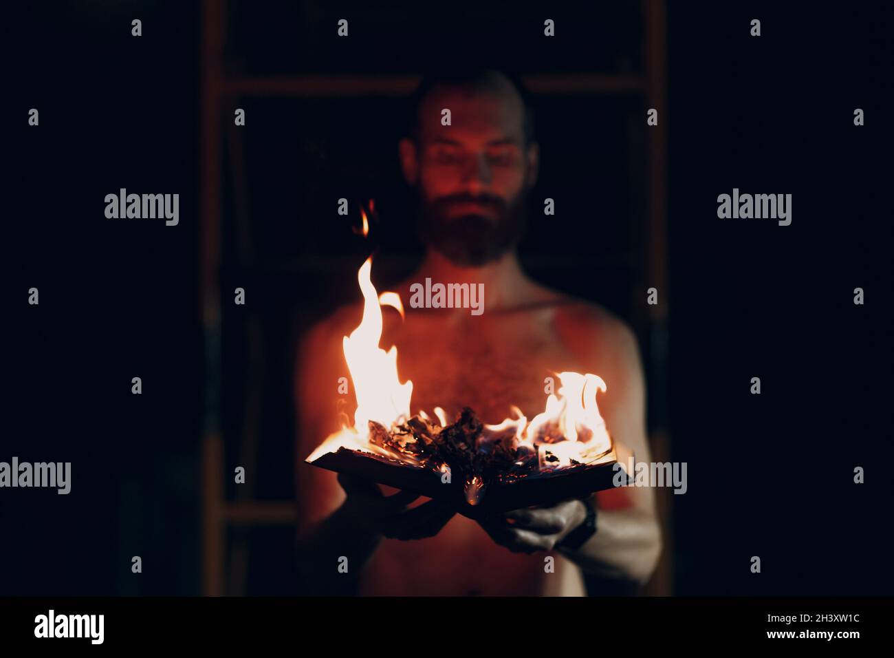Man hold burning book in his hands Stock Photo - Alamy
