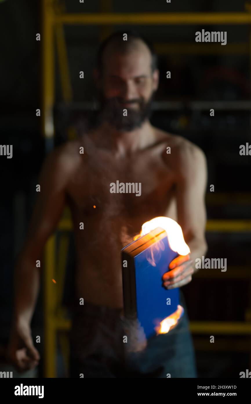 Man hold burning book in his hands Stock Photo - Alamy