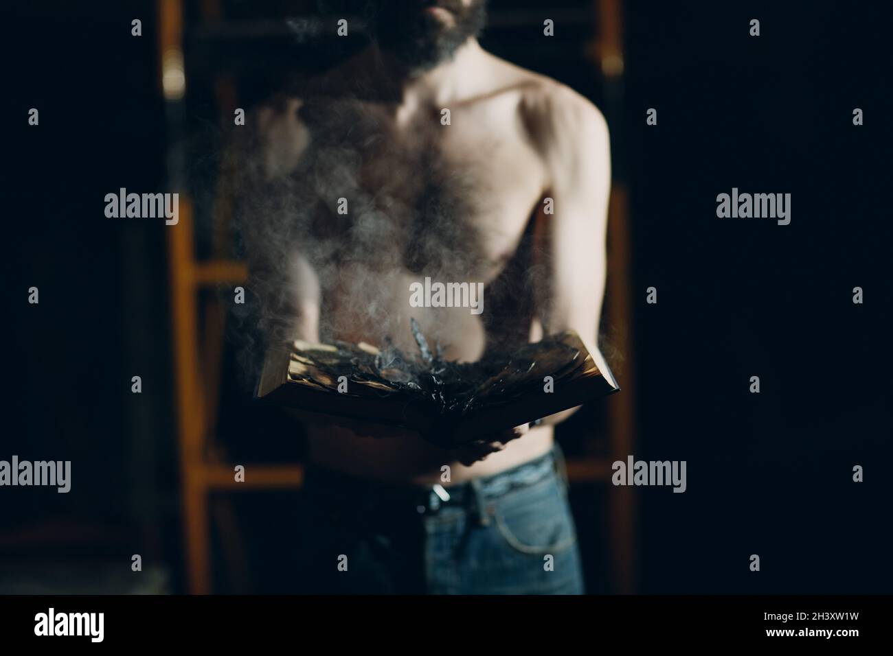 Man hold burning book in his hands Stock Photo - Alamy
