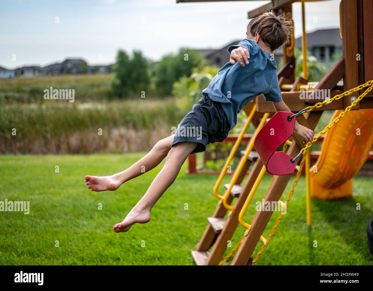 Caucasian male boy jumping from a swing set in midair falling Stock ...