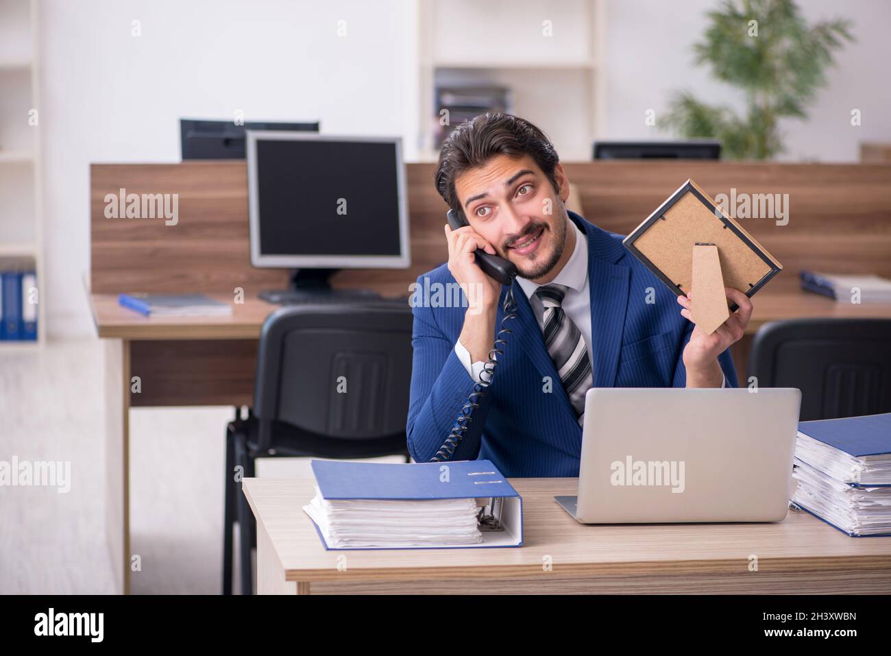 Young male employee missing girlfriend at workplace Stock Photo - Alamy