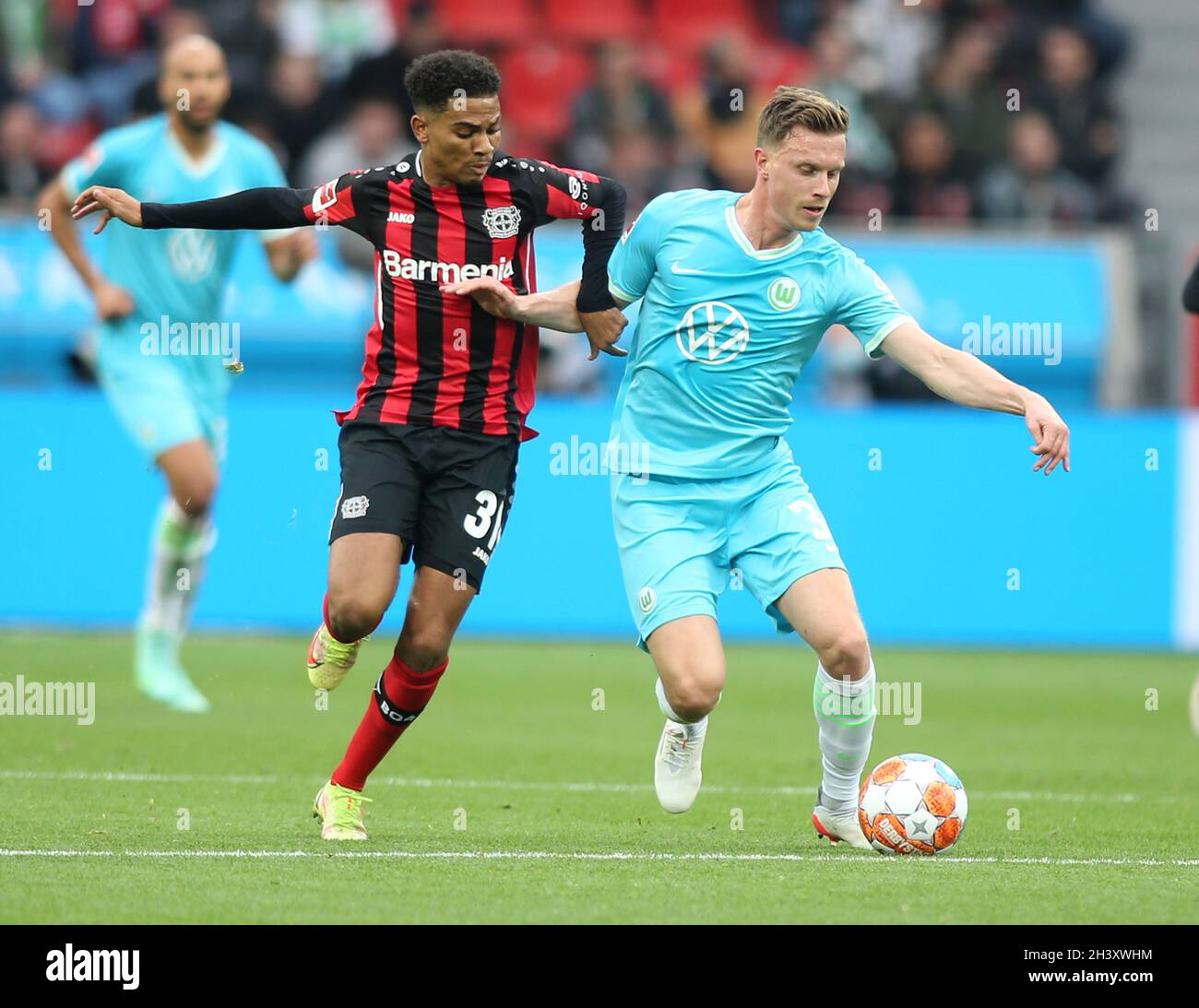 Sebastiaan Bornauw of Wolfsburg, (right ), and Amine Adli of Bayer 04 ...
