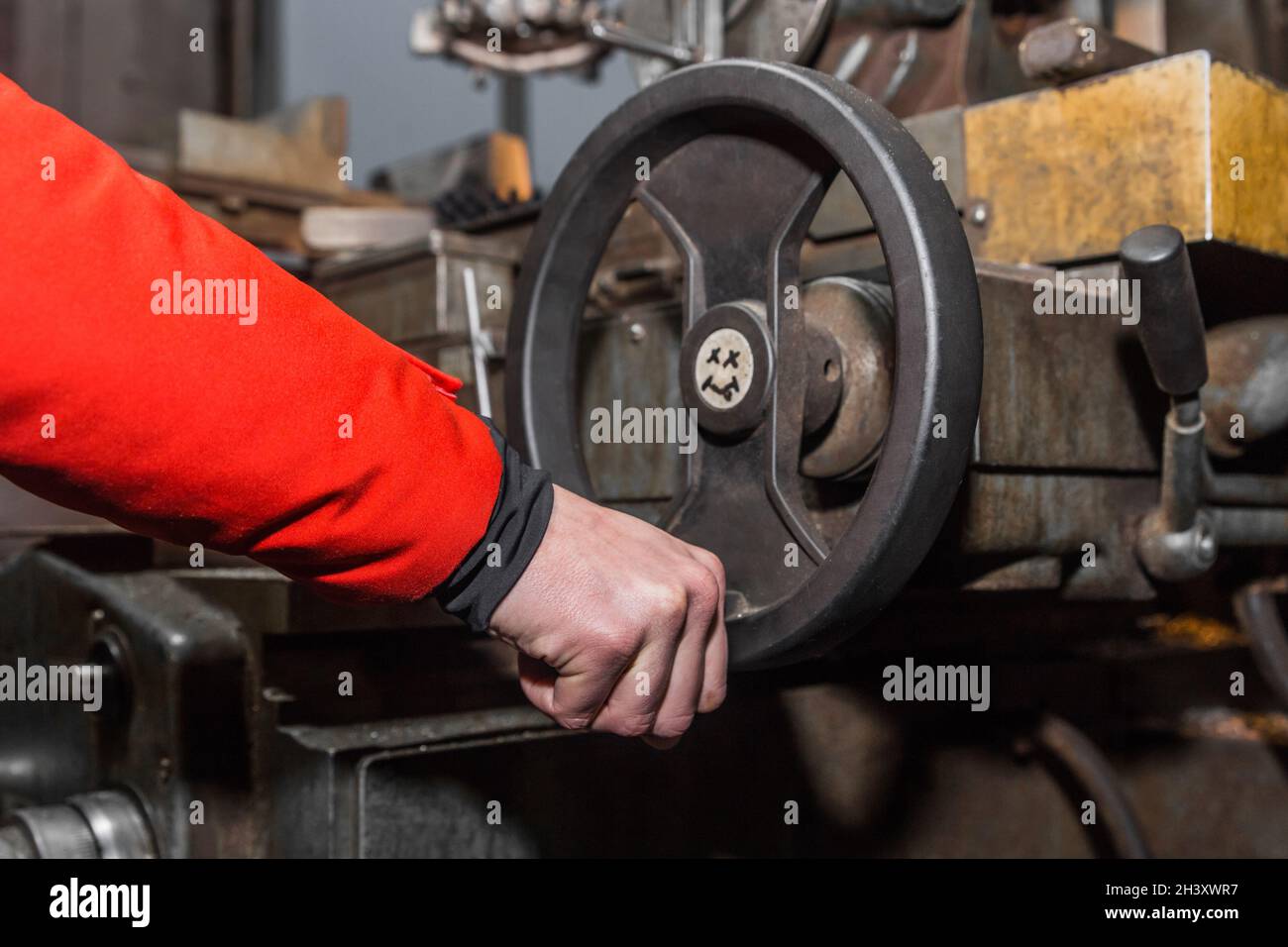 The hand of a man worker holds a special, steering wheel by the handle ...