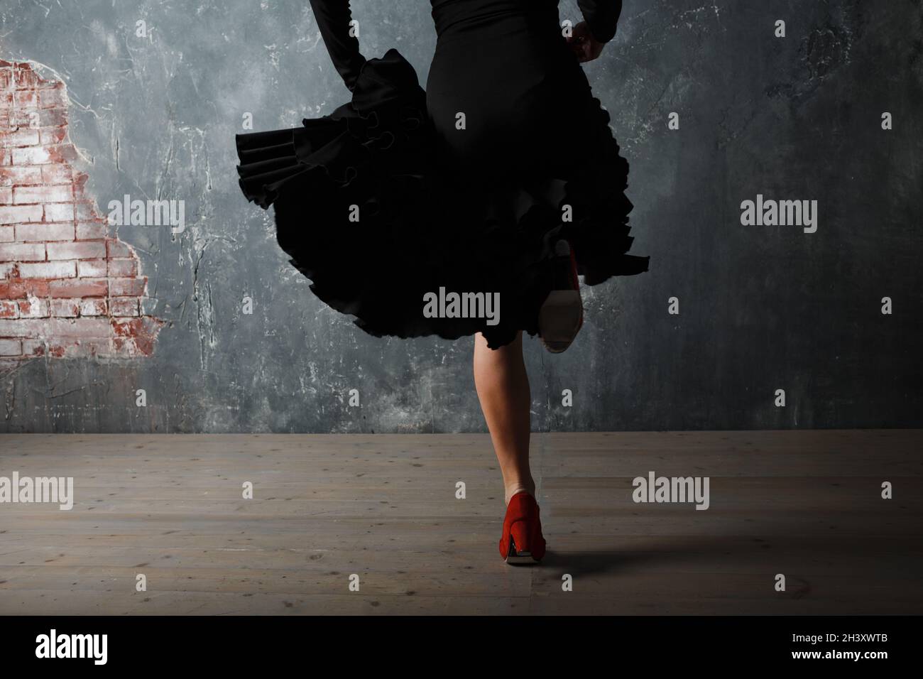 Young adult spanish woman dancing flamenco on gray vintage background ...