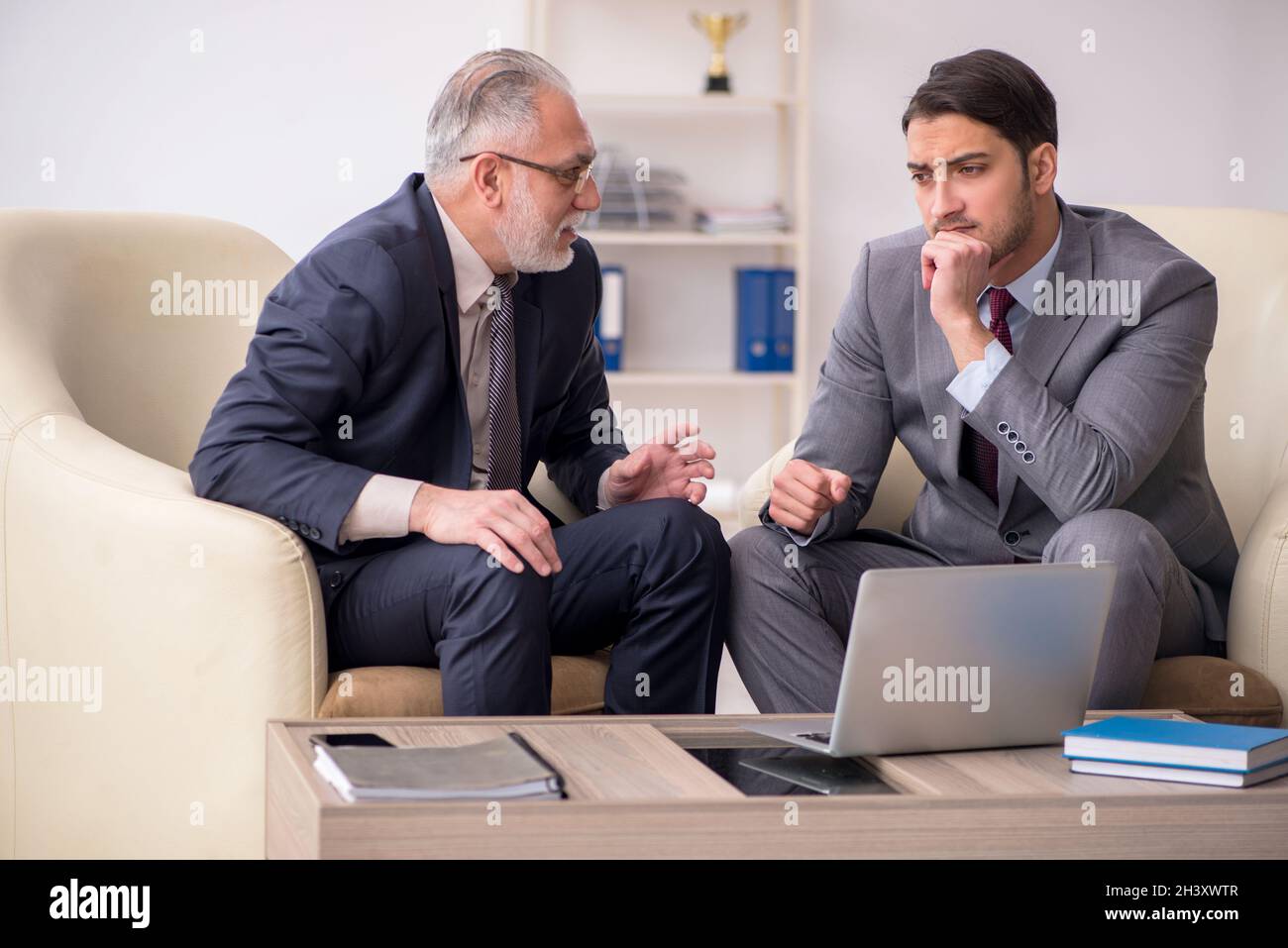 Two businessmen discussing project at workplace Stock Photo - Alamy